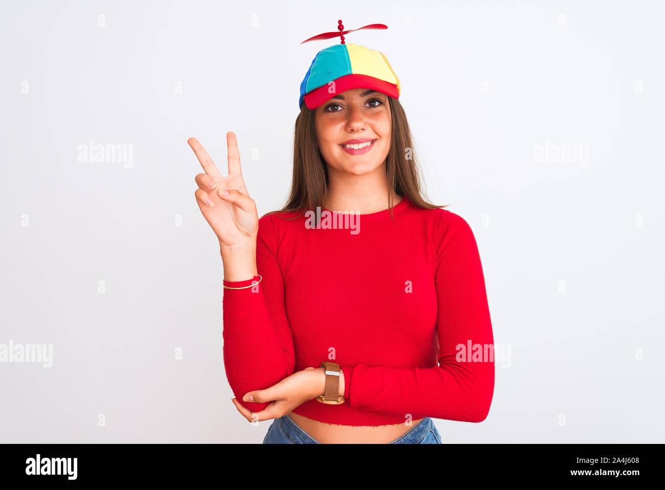 Young beautiful girl wearing fanny cap with propeller standing over ...