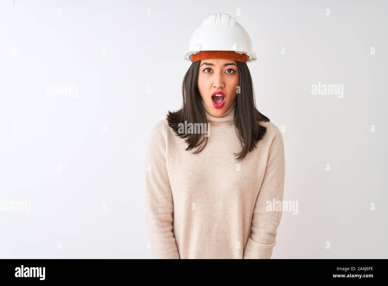 Young chinese architect woman wearing security helmet over isolated ...