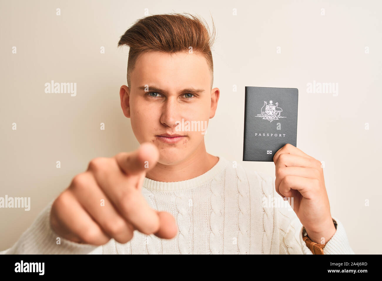 Young handsome man holding Australia Australian passport over isolated ...