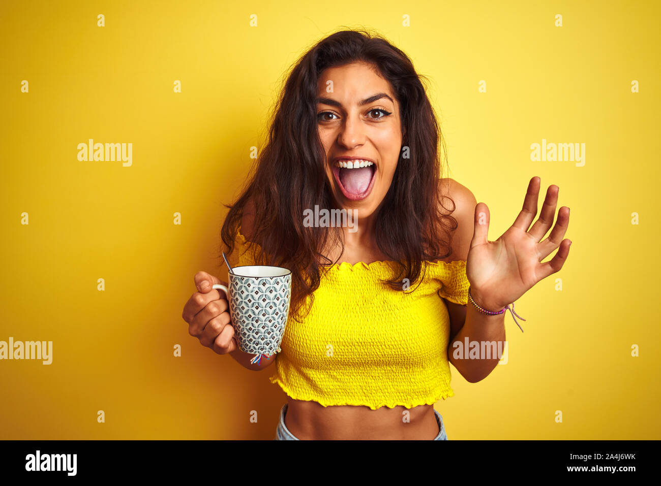 Young beautiful woman drinking cup of coffee standing over isolated ...