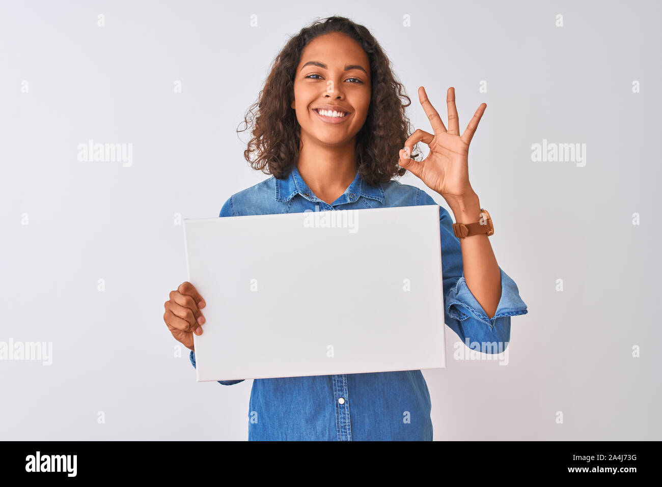 Young brazilian woman holding banner standing over isolated white ...