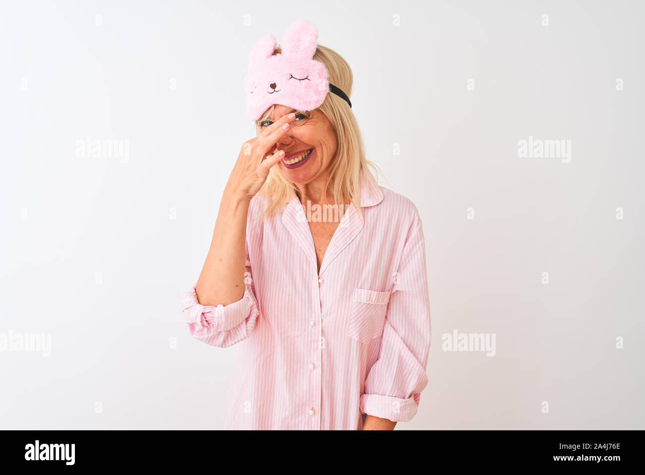 Middle age woman wearing sleep mask and pajama over isolated white ...