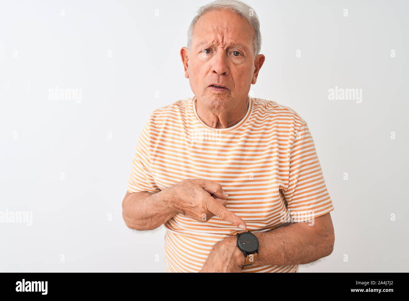 Senior grey-haired man wearing striped t-shirt standing over isolated ...