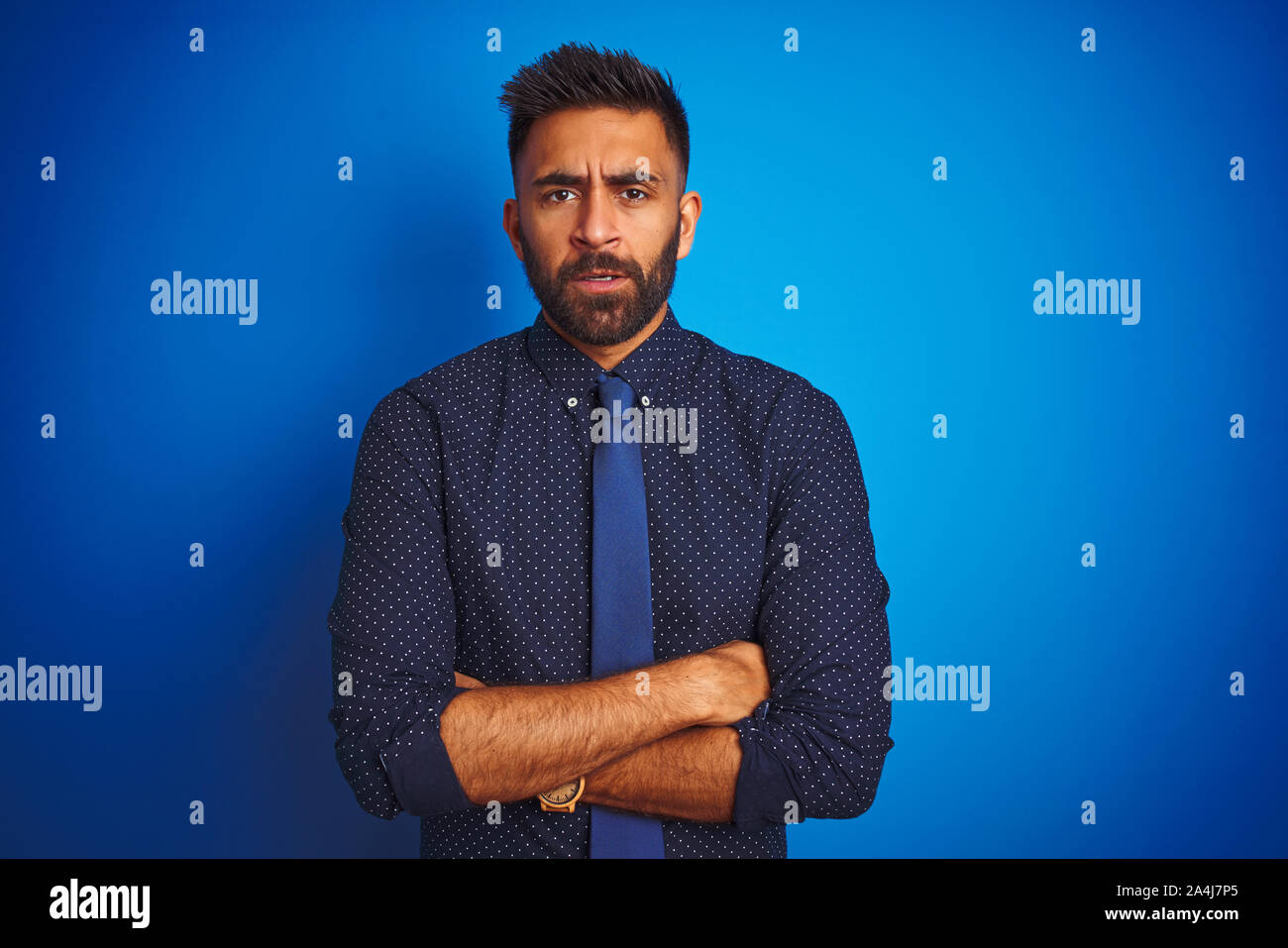 Young indian businessman wearing elegant shirt and tie standing over ...