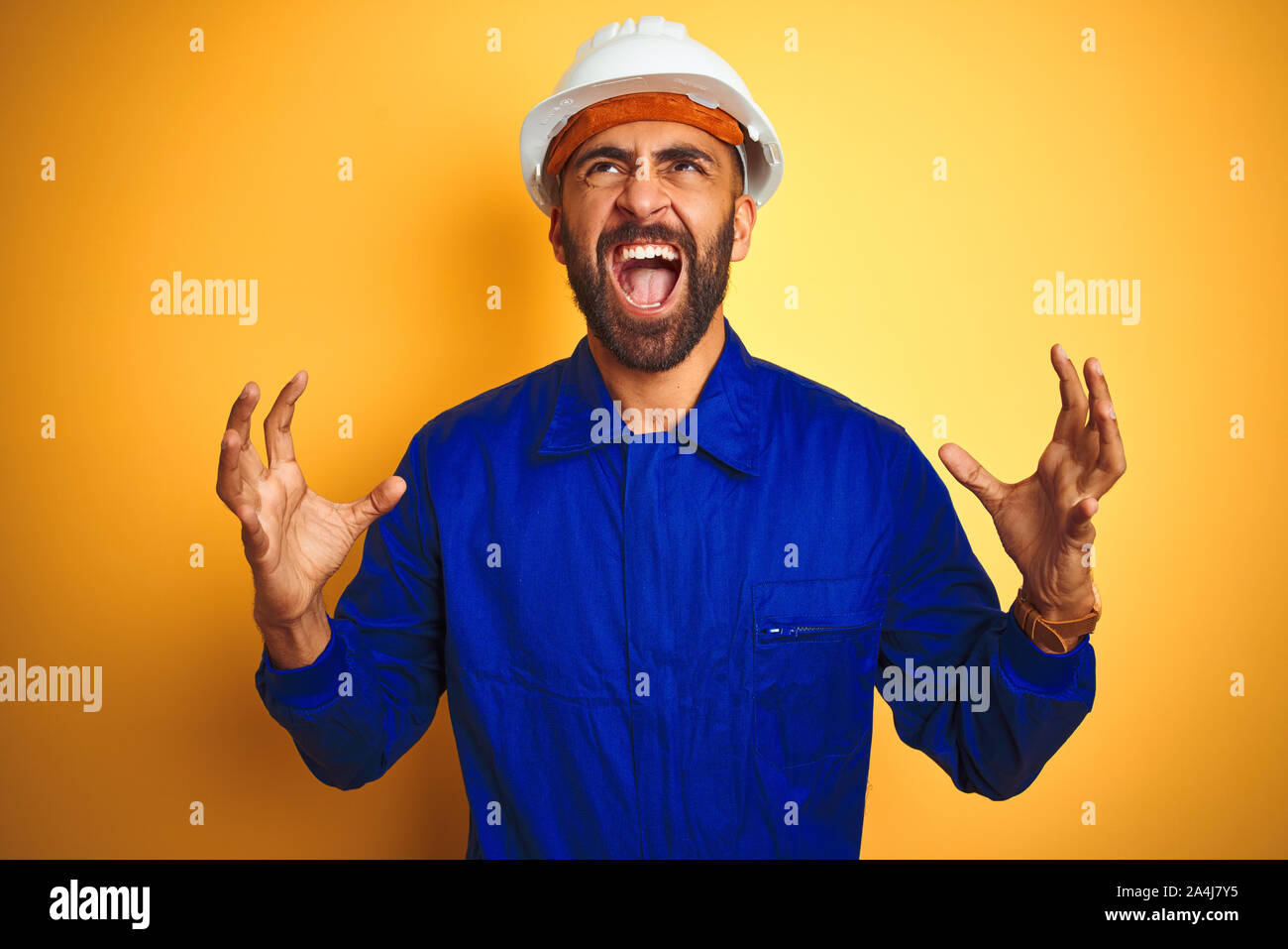 Handsome indian worker man wearing uniform and helmet over isolated ...