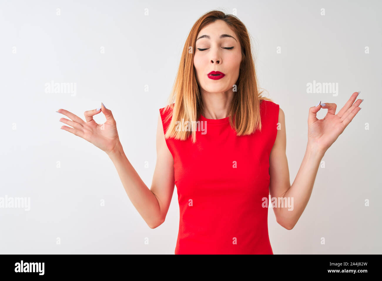 Redhead businesswoman wearing elegant red dress standing over isolated ...