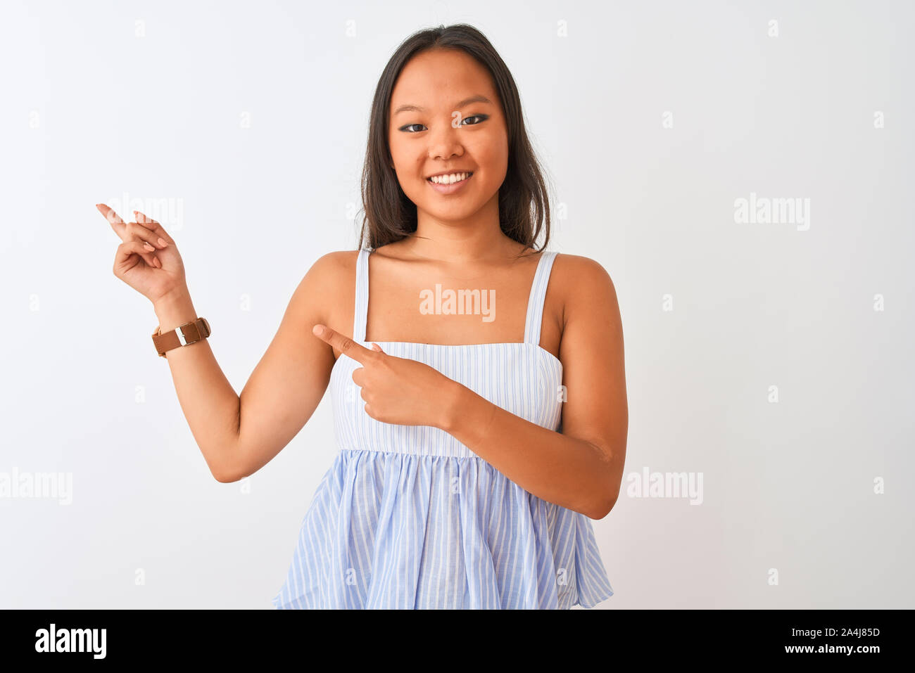 Young chinese woman wearing casual striped dress standing over isolated ...