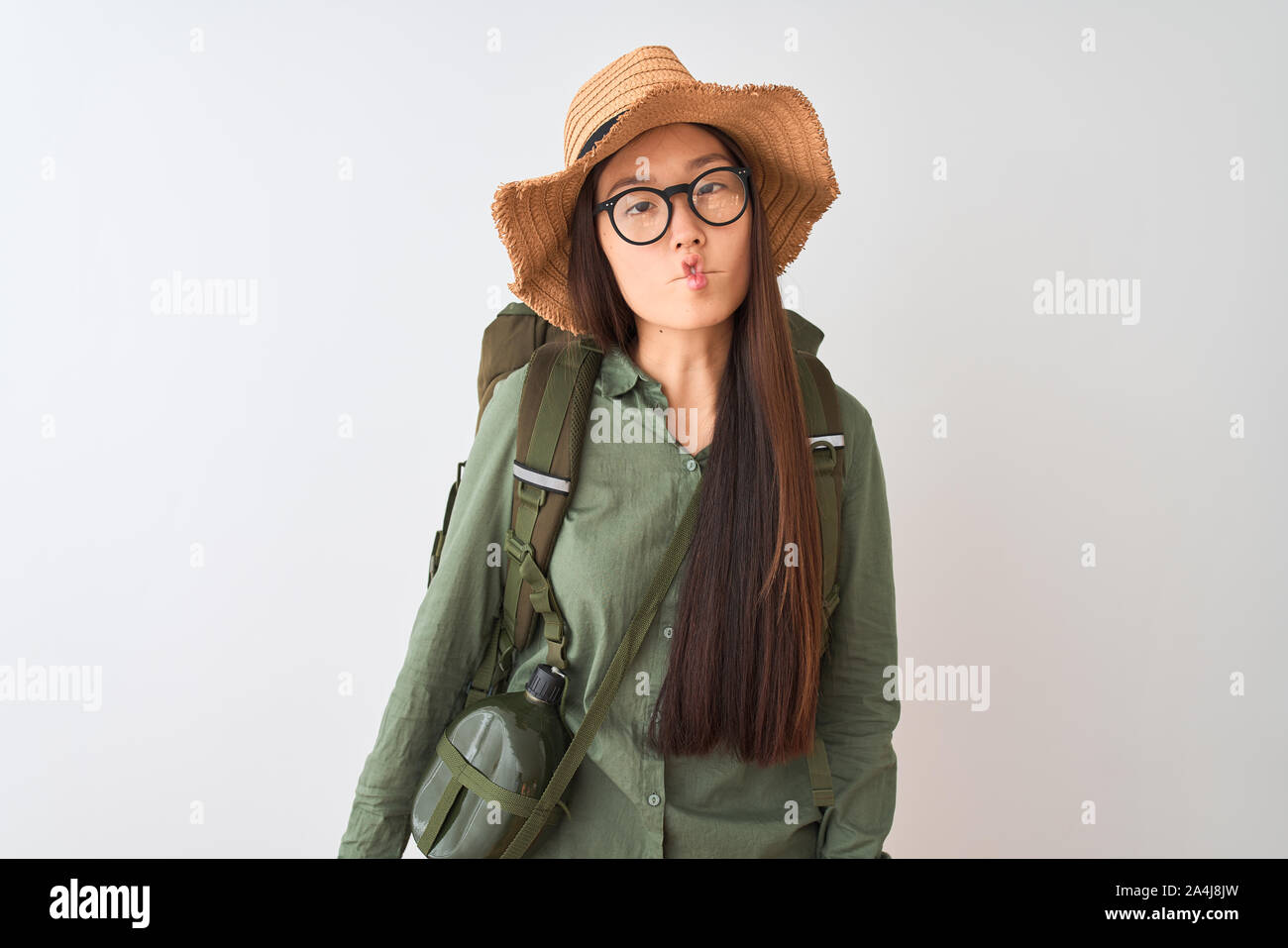 Chinese hiker woman wearing canteen hat glasses backpack over isolated ...