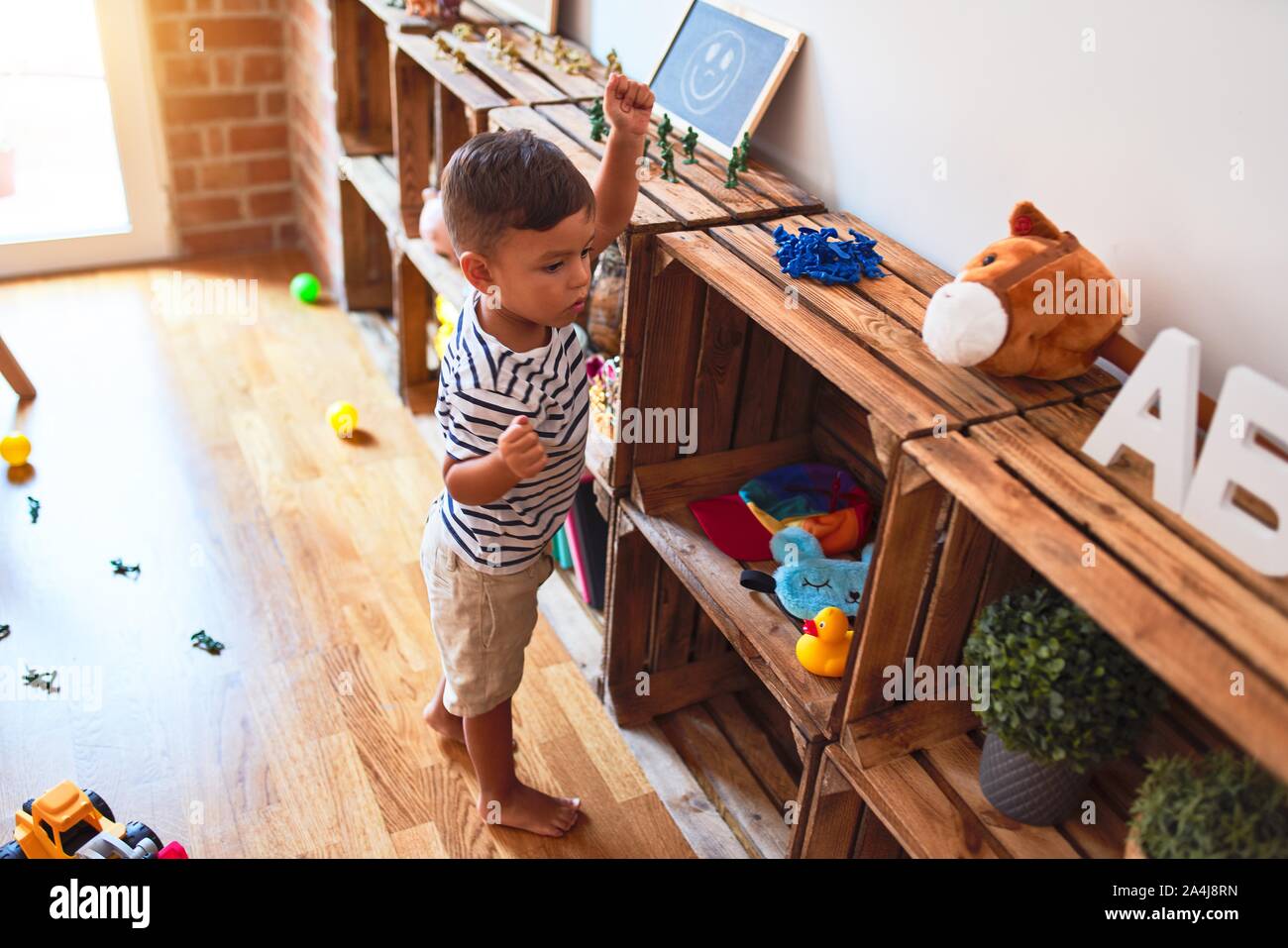 Beautiful toddler boy playing with figurine army soldiers at ...