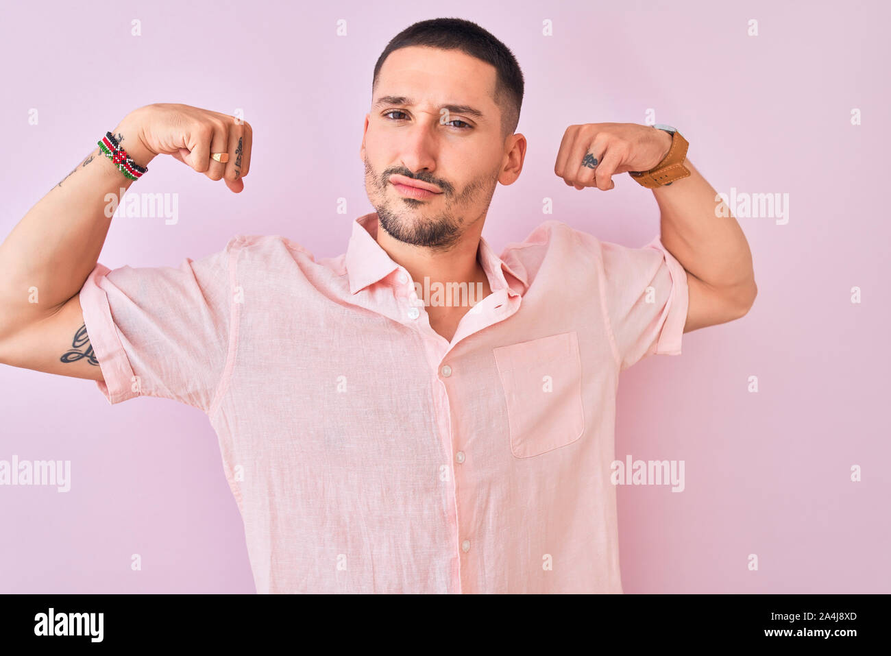 Young handsome man wearing pink shirt standing over isolated background ...