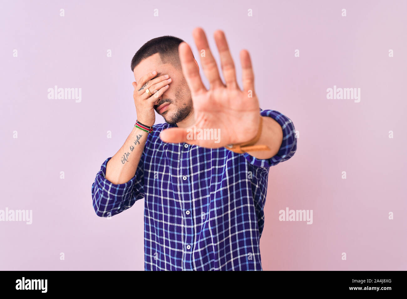Young handsome man standing over isolated background covering eyes with ...