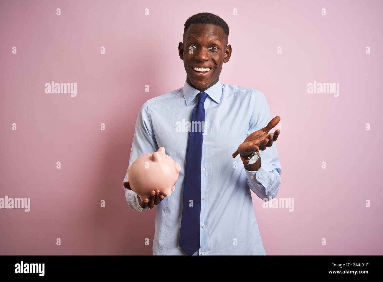 African american businessman holding piggy bank standing over isolated ...