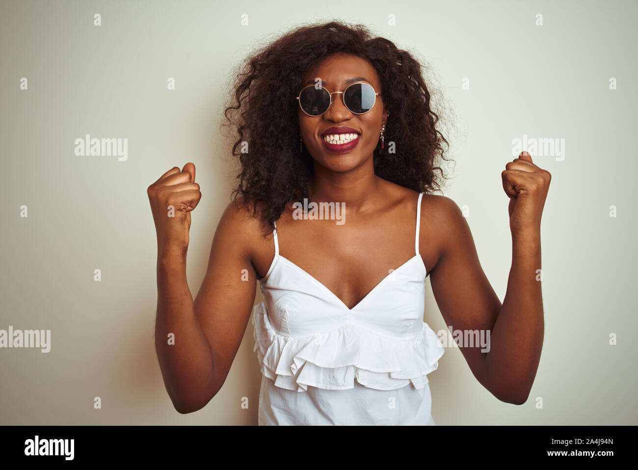 Young african american woman wearing t-shirt and sunglasses over ...