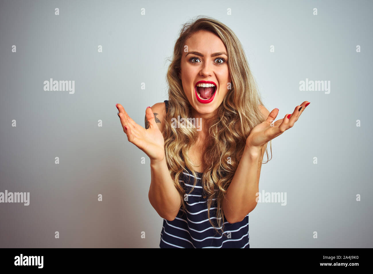 Young beautiful woman wearing stripes t-shirt standing over white ...