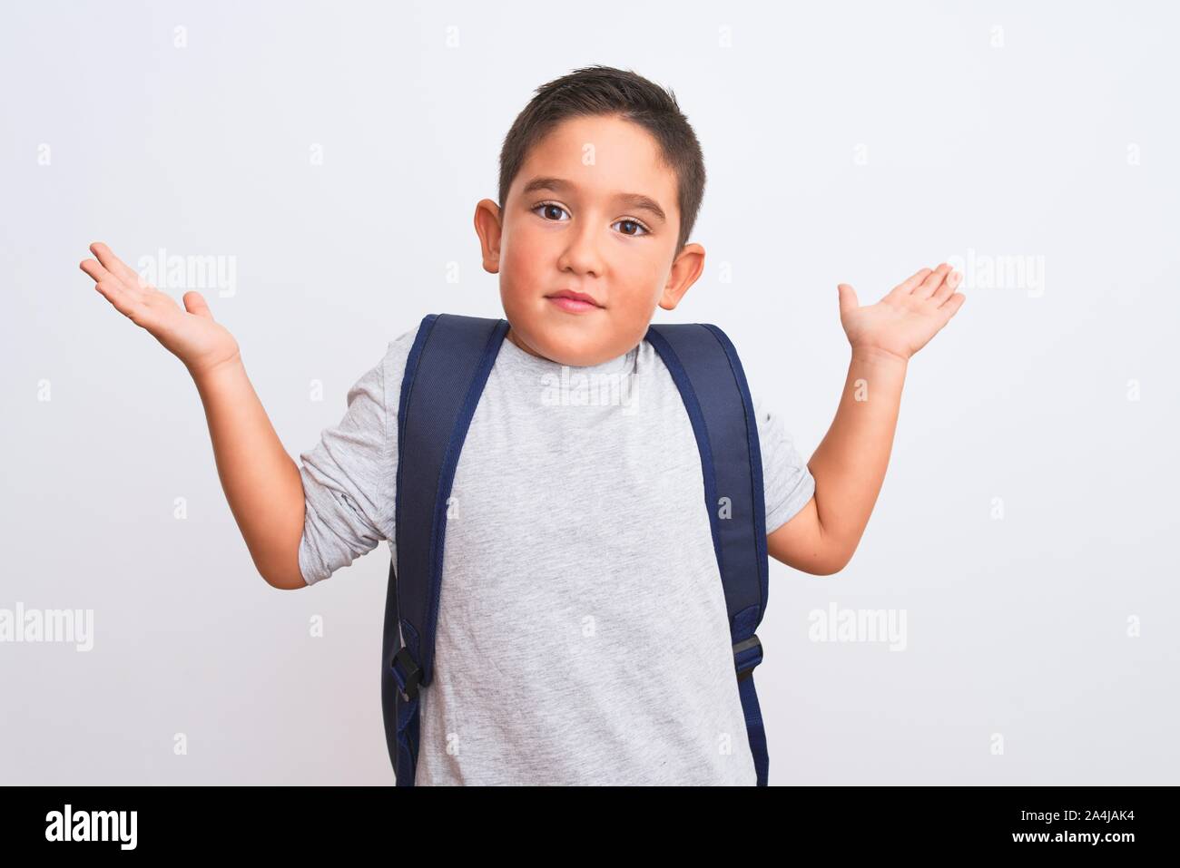 Beautiful student kid boy wearing backpack standing over isolated white ...