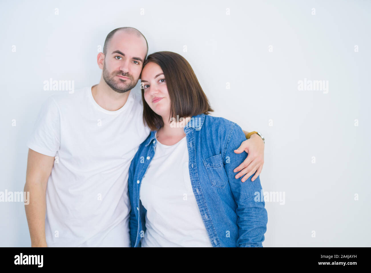 Young couple together over white isolated background with serious ...