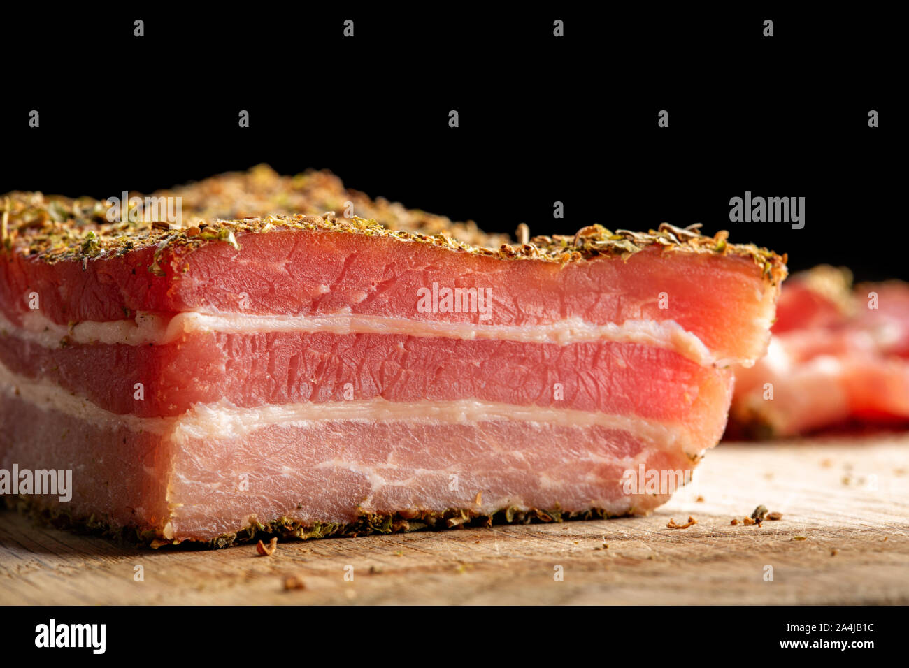 Appetizer cured pork belly in spices of herbs on a cutting board Stock ...