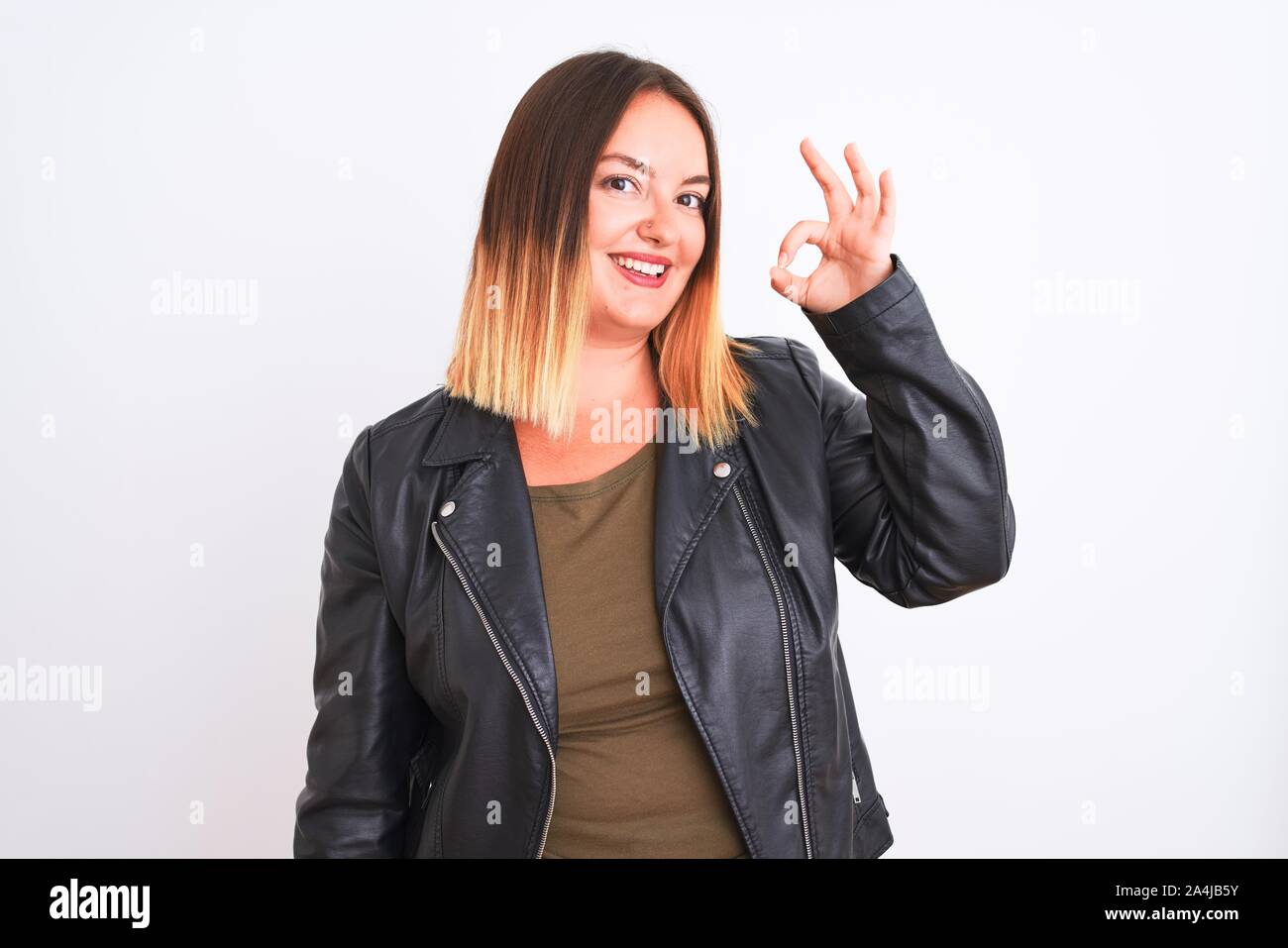Young beautiful woman wearing t-shirt and jacket standing over isolated ...