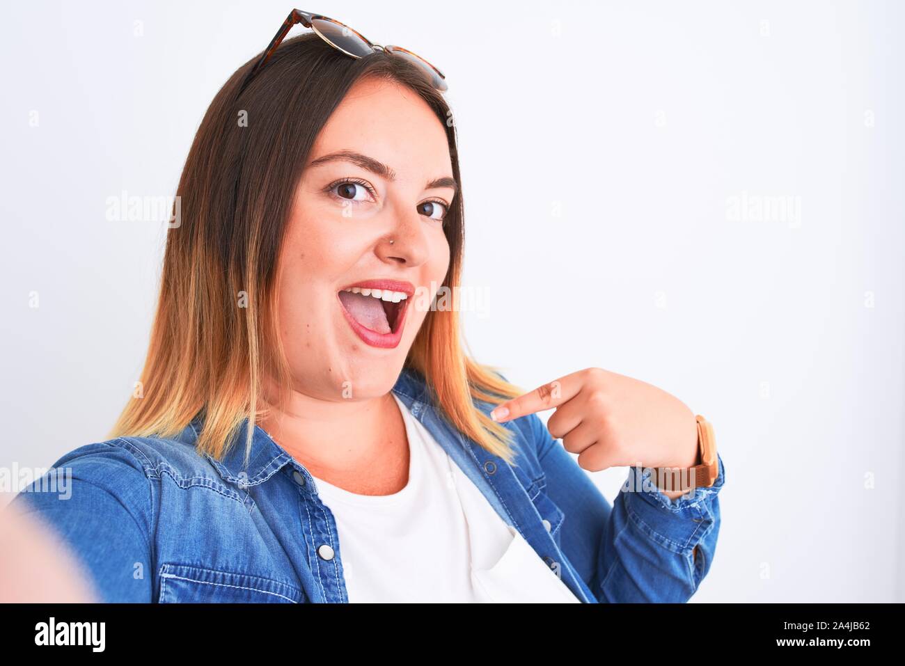 Young beautiful woman wearing denim shirt standing over isolated white ...