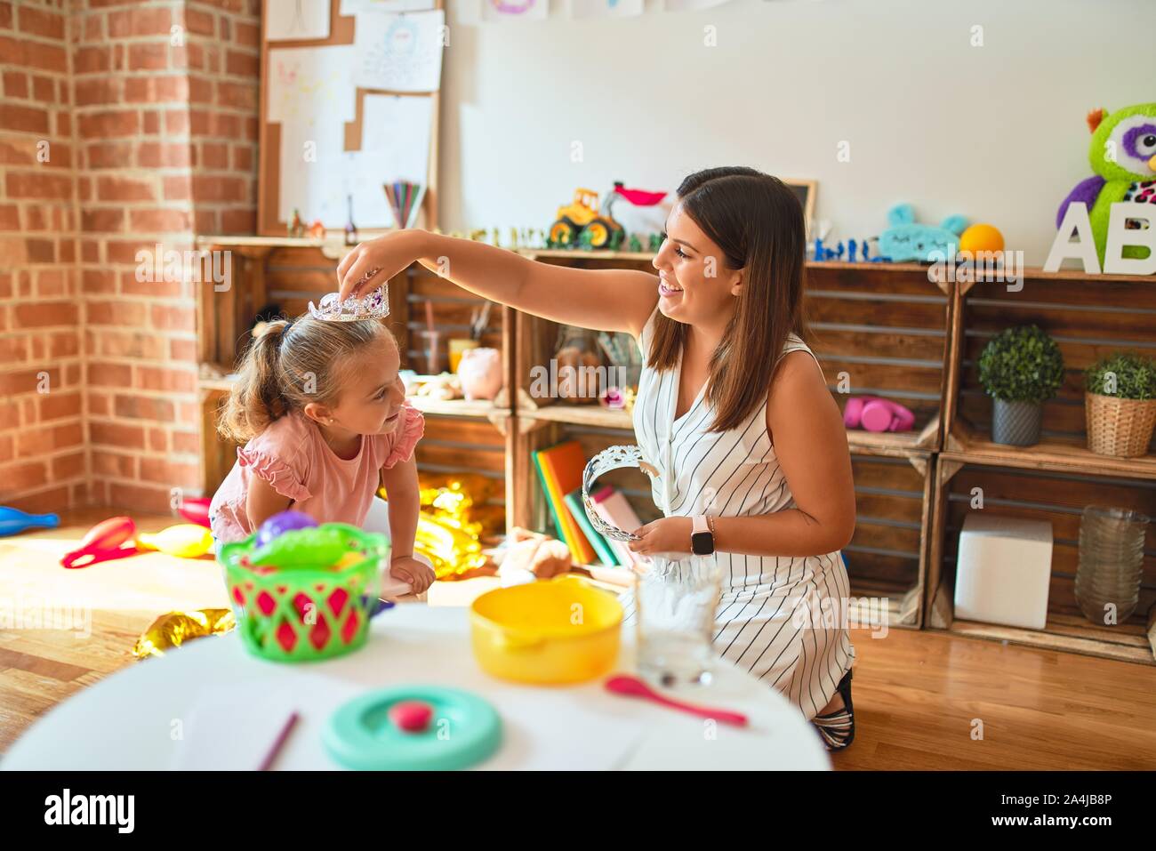Beautiful teacher and blond student toddler girl playing to be a ...