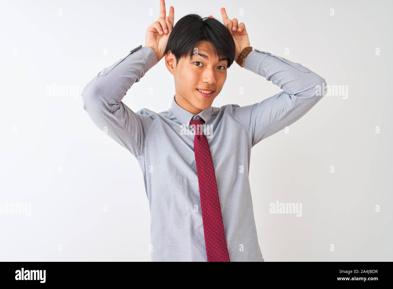 Chinese businessman wearing elegant tie standing over isolated white background Posing funny and ...