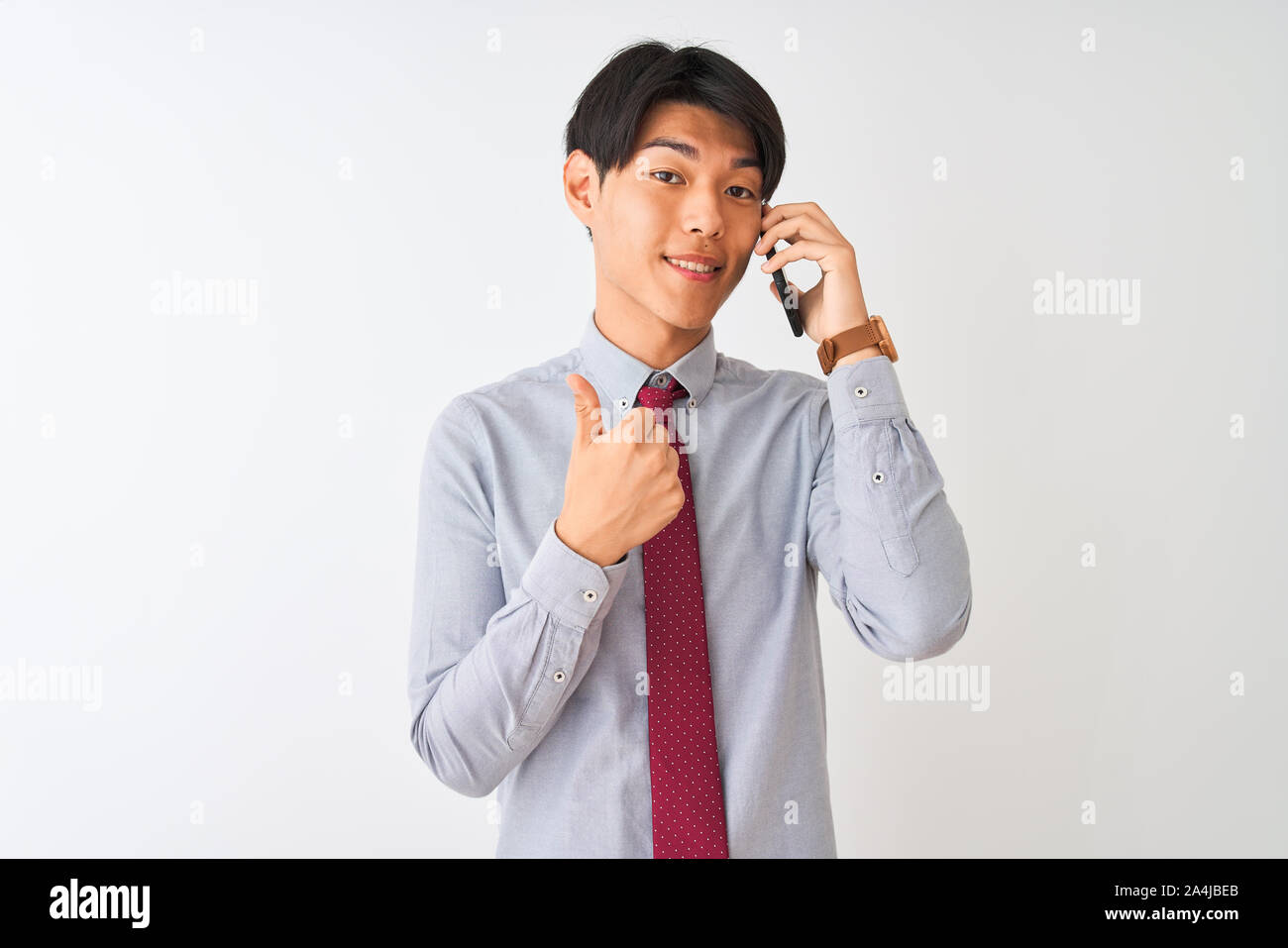 Chinese businessman wearing tie talking on the smartphone over isolated ...