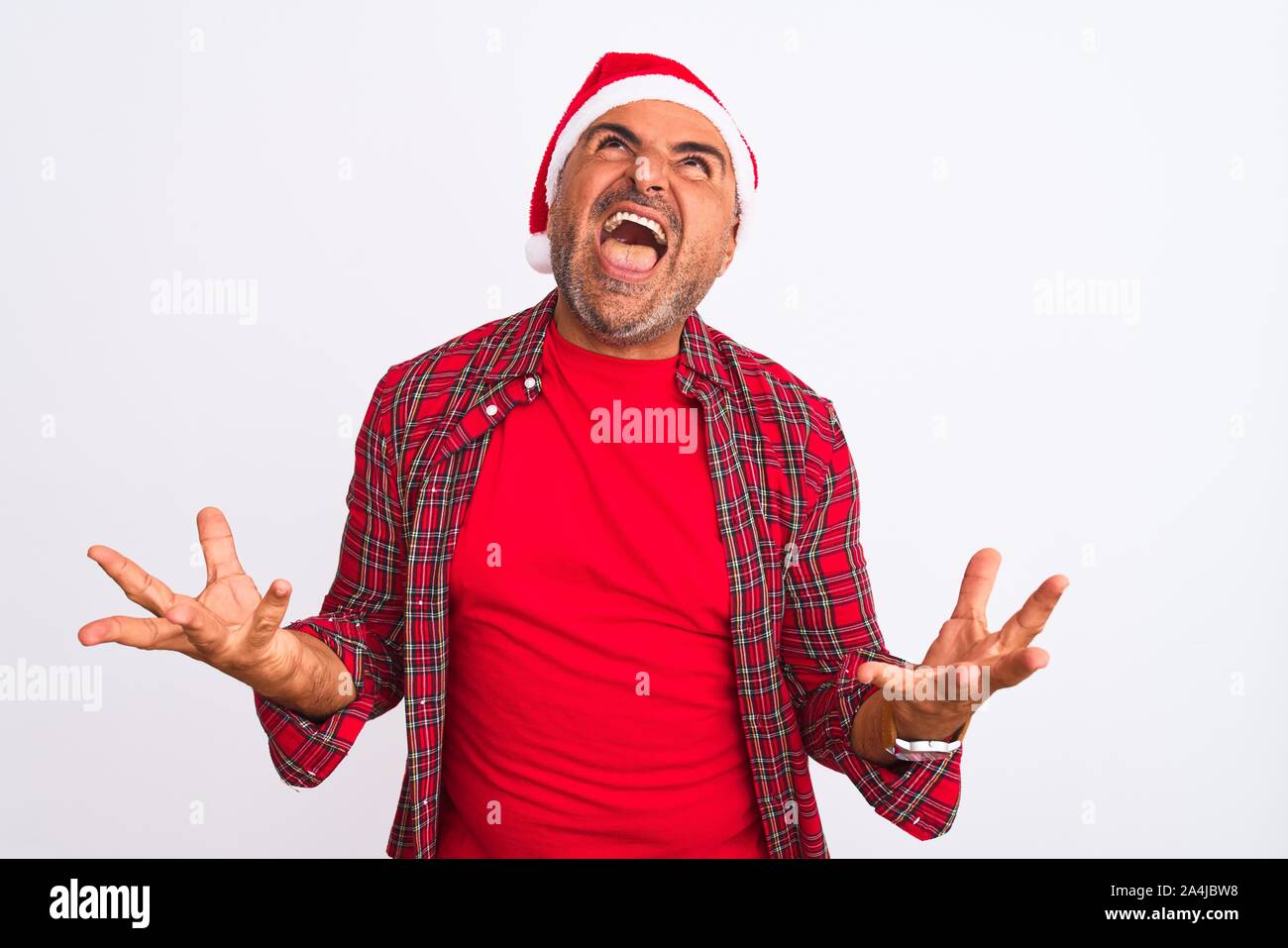 Middle age man wearing Christmas Santa hat standing over isolated white ...