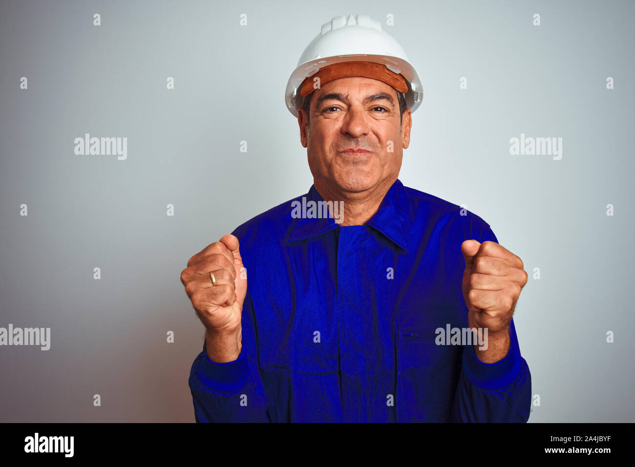 Handsome middle age worker man wearing uniform and helmet over isolated ...