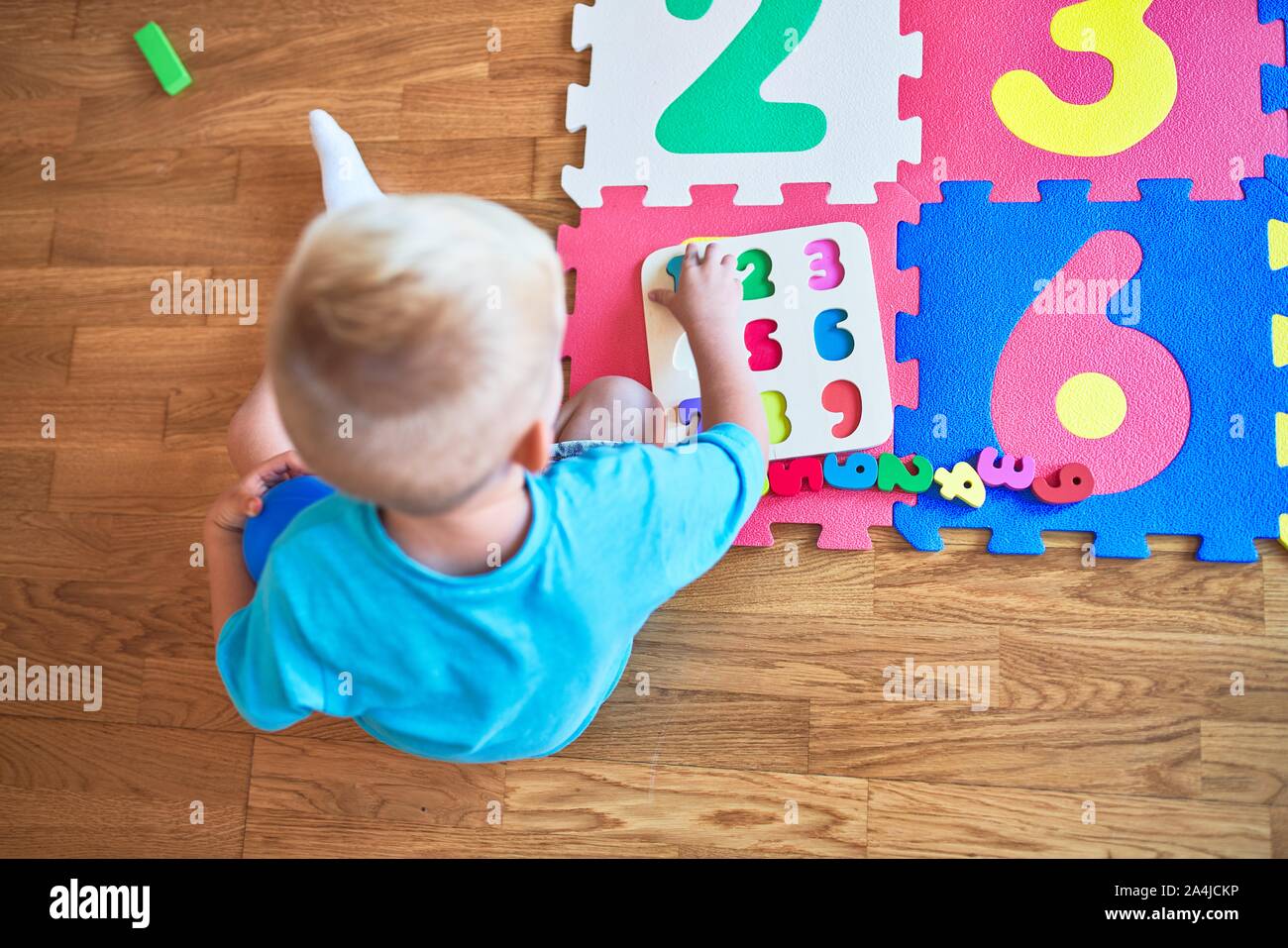 Young caucasian kid playing placing numbers at kindergarten ...