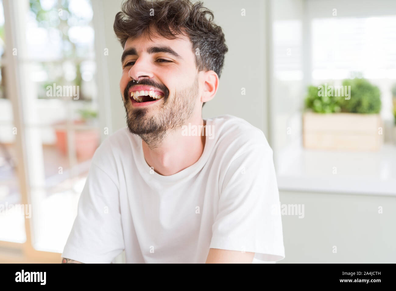 Handsome young man smiling cheerful at the camera with a big smile on ...