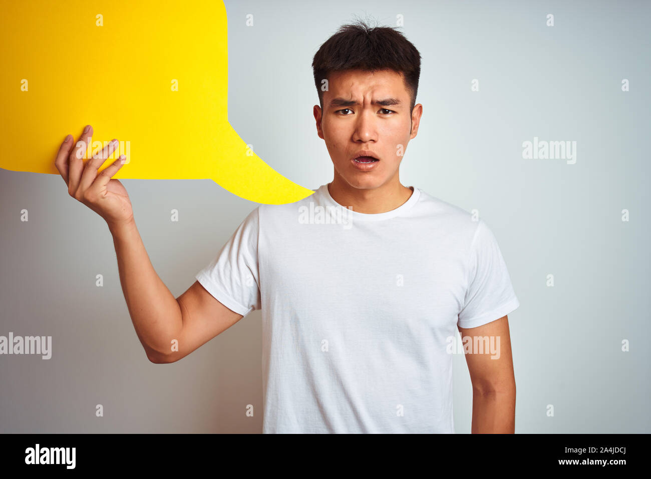 Asian chinese man holding speech bubble standing over isolated white ...