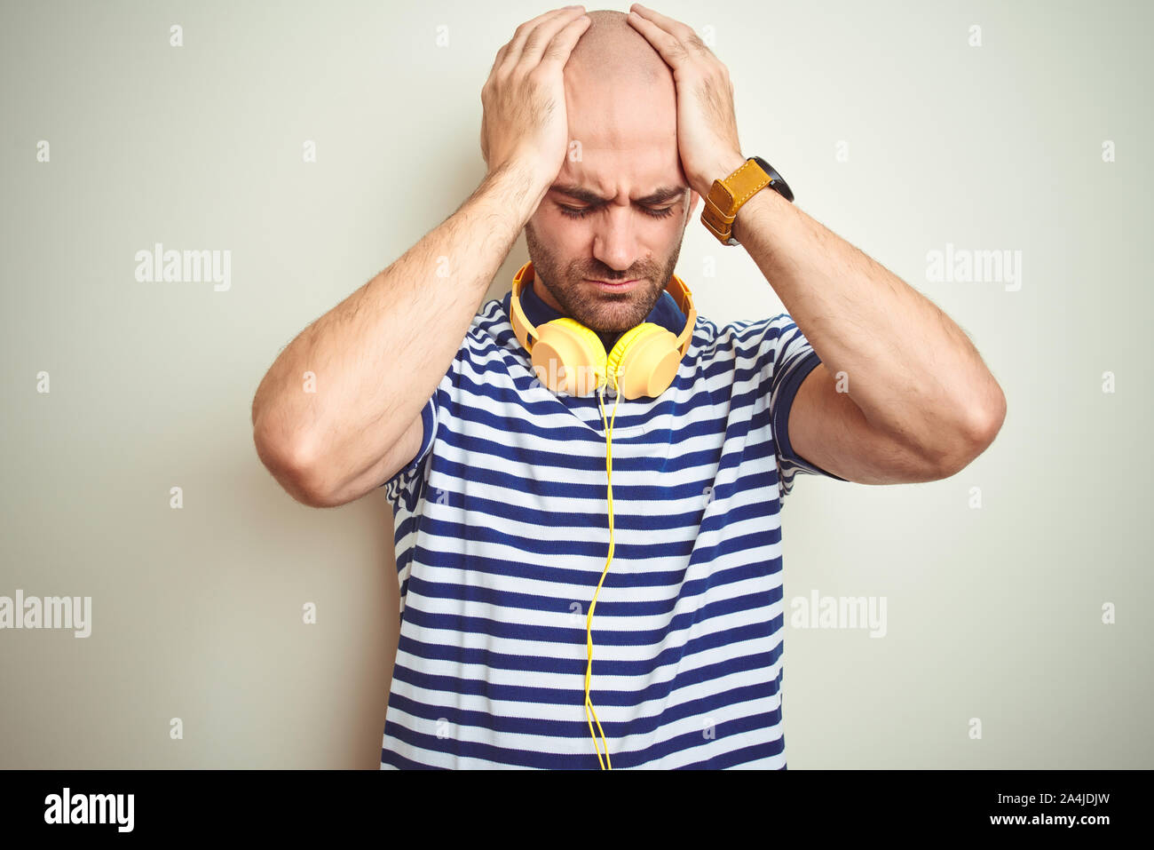 Young man listening to music wearing yellow headphones over isolated ...