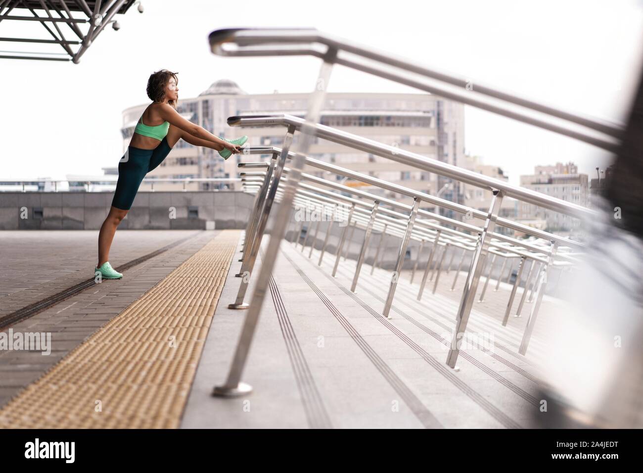 woman runner stretching leg muscle before running outdoors for athlete ...