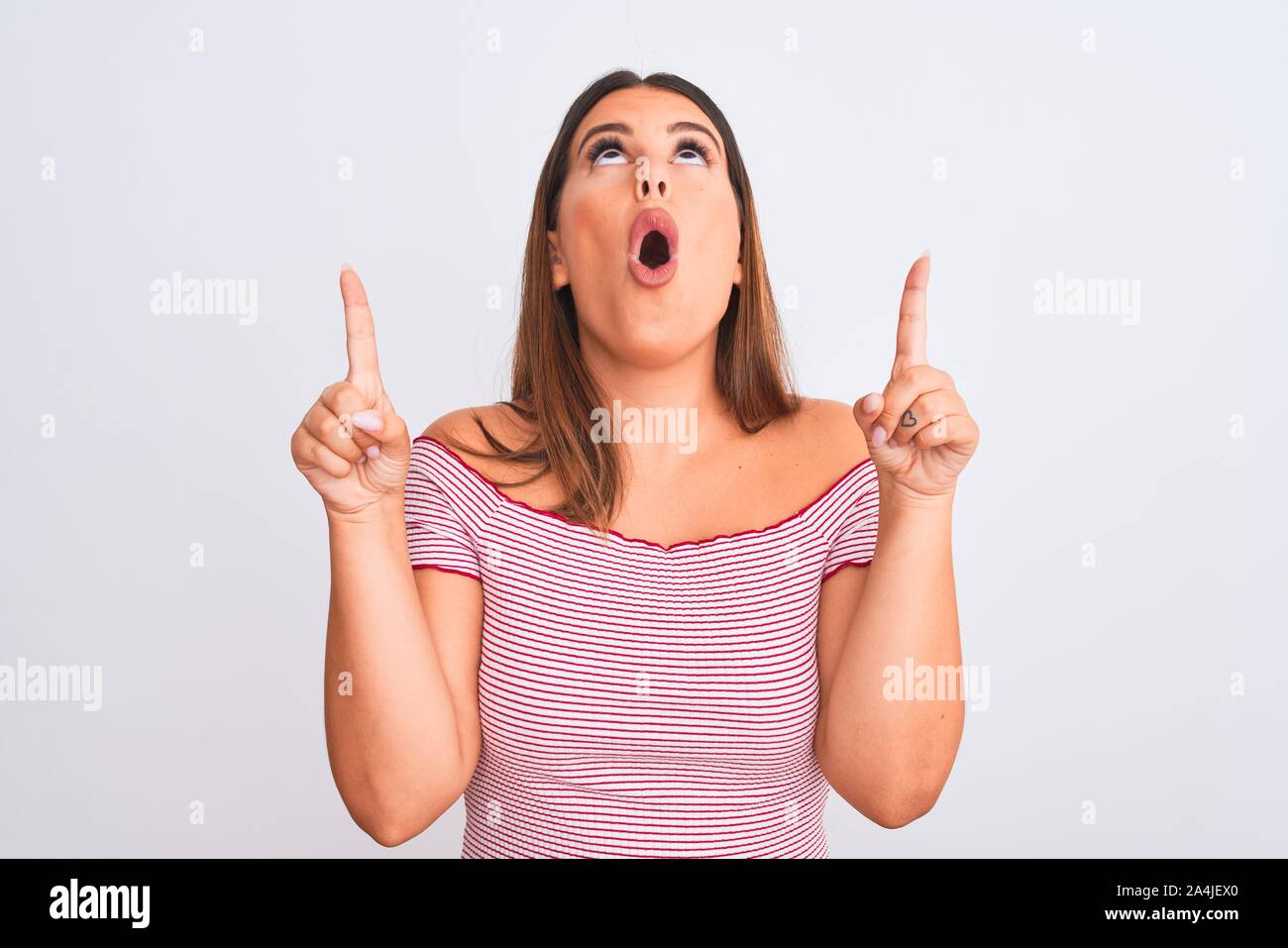 Portrait of beautiful young woman standing over isolated white ...