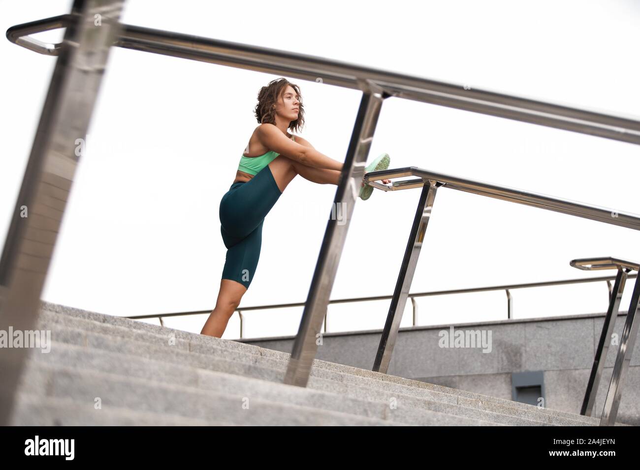 woman runner stretching leg muscle before running outdoors for athlete ...