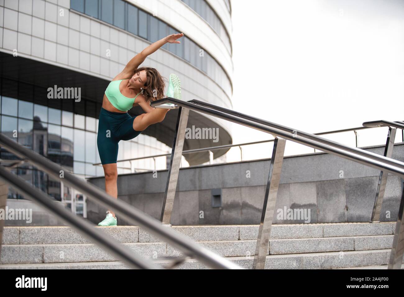 woman runner stretching leg muscle before running outdoors for athlete ...