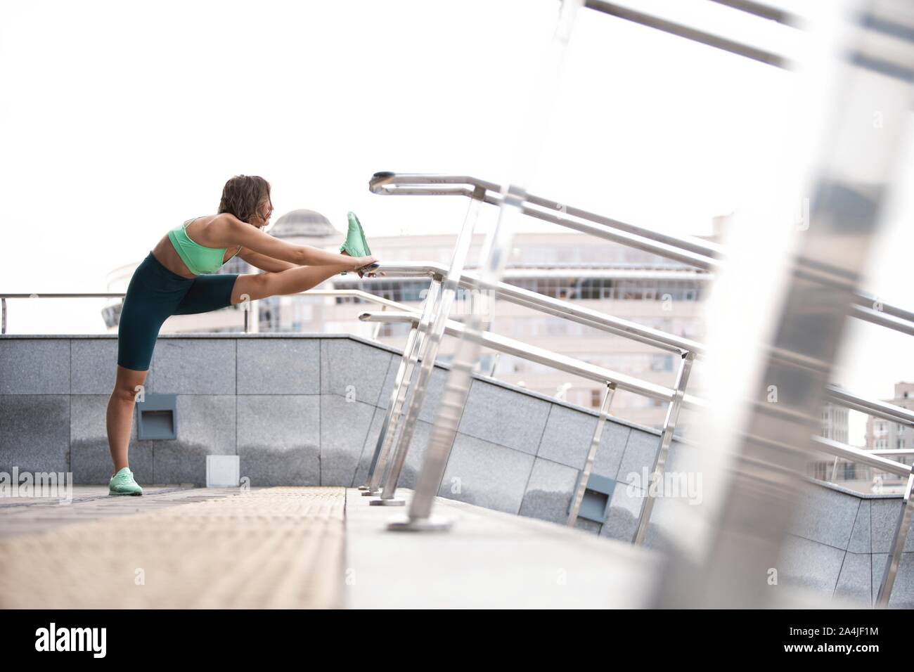 woman runner stretching leg muscle before running outdoors for athlete ...