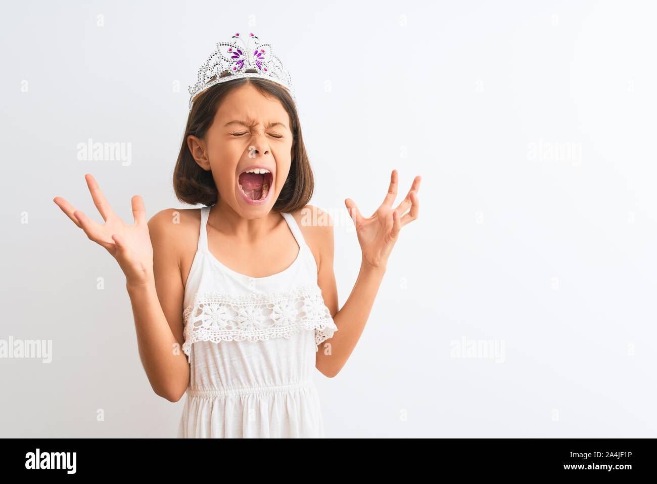 Beautiful child girl wearing princess crown standing over isolated ...