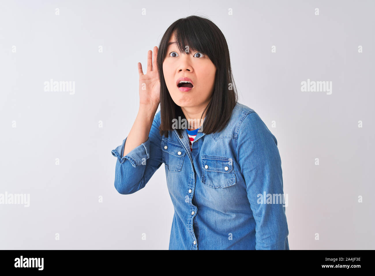 Young beautiful chinese woman wearing denim shirt over isolated white ...