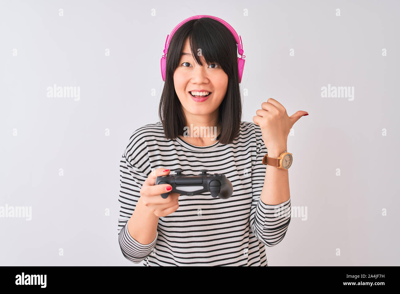 Chinese gamer woman playing video game using headphones over isolated ...