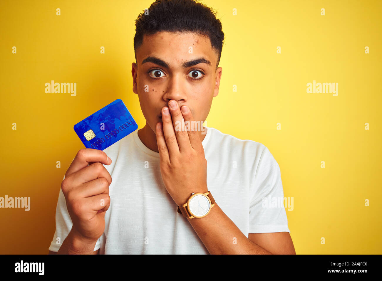 Young brazilian customer man holding credit card standing over isolated ...