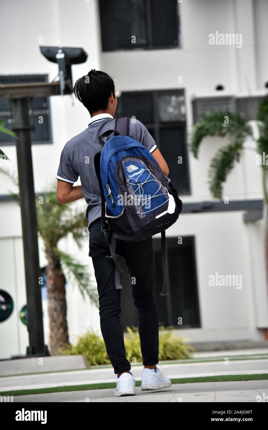 Male Student Walking On Campus Wearing Backpack Stock Photo - Alamy