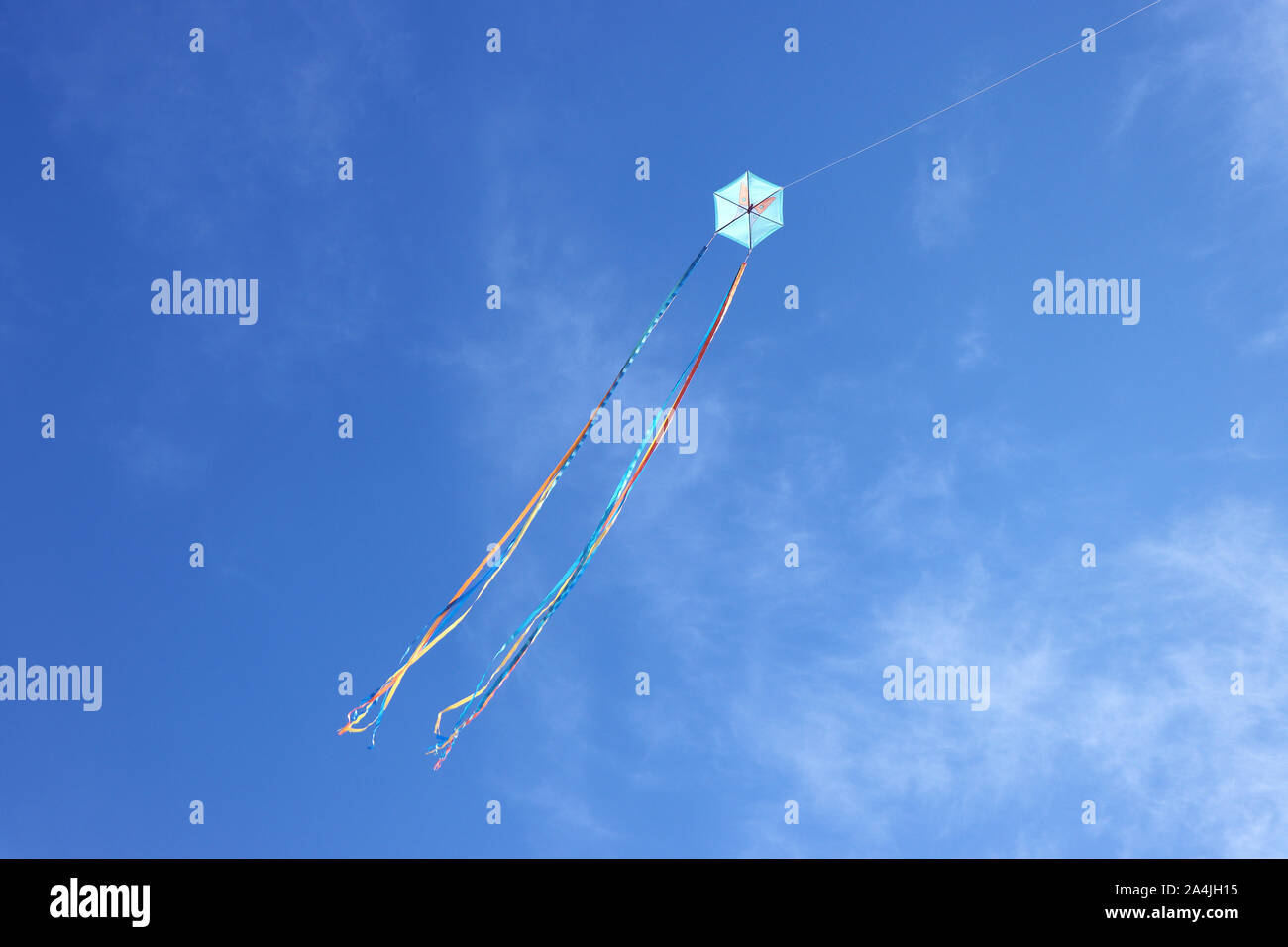 Colorful kite flying and blue sky as background Stock Photo - Alamy