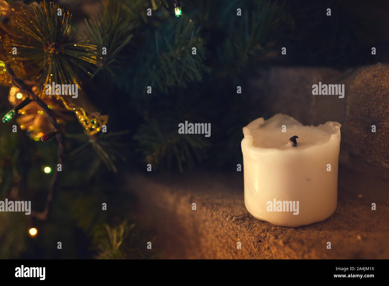 White extinct candle near to Christmas tree. Close-up Stock Photo - Alamy