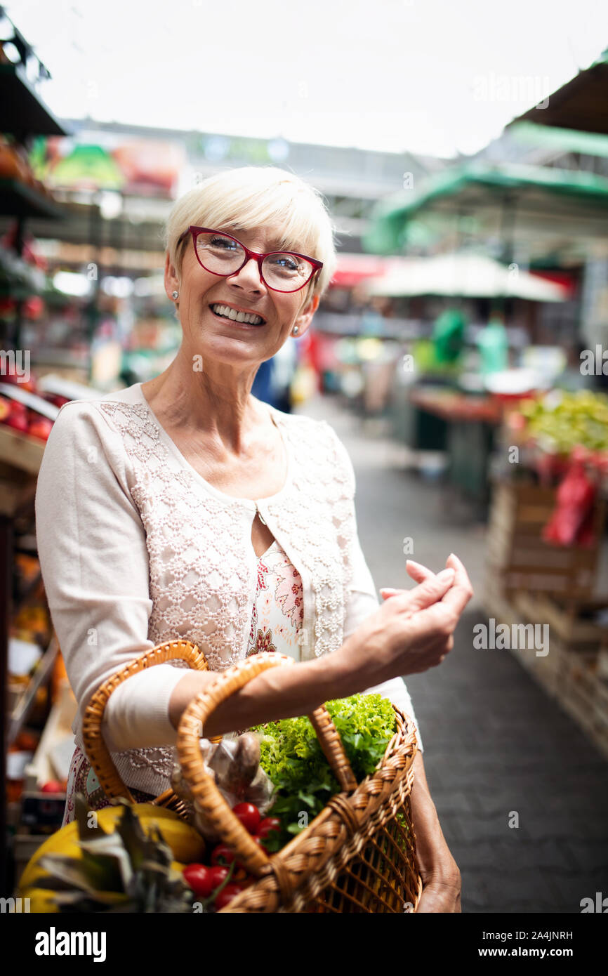 Only the best fruits and vegetables. Beautiful mature woman buying ...