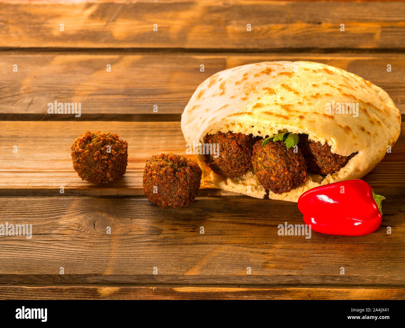 Falafel balls, pita-arabian bread and fresh vegetables on a wooden ...