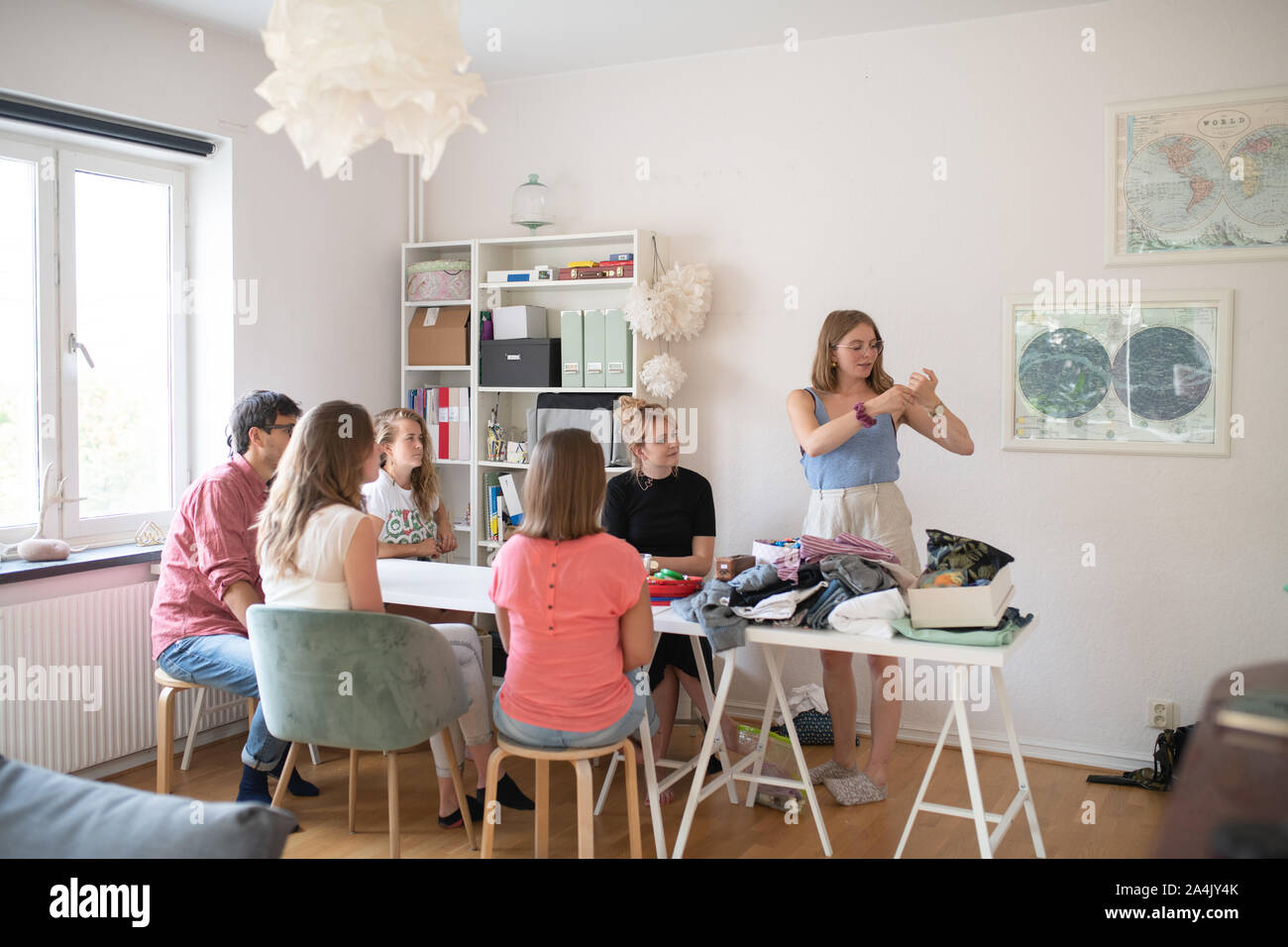 teacher instructing students at embroidery and recycled material class ...
