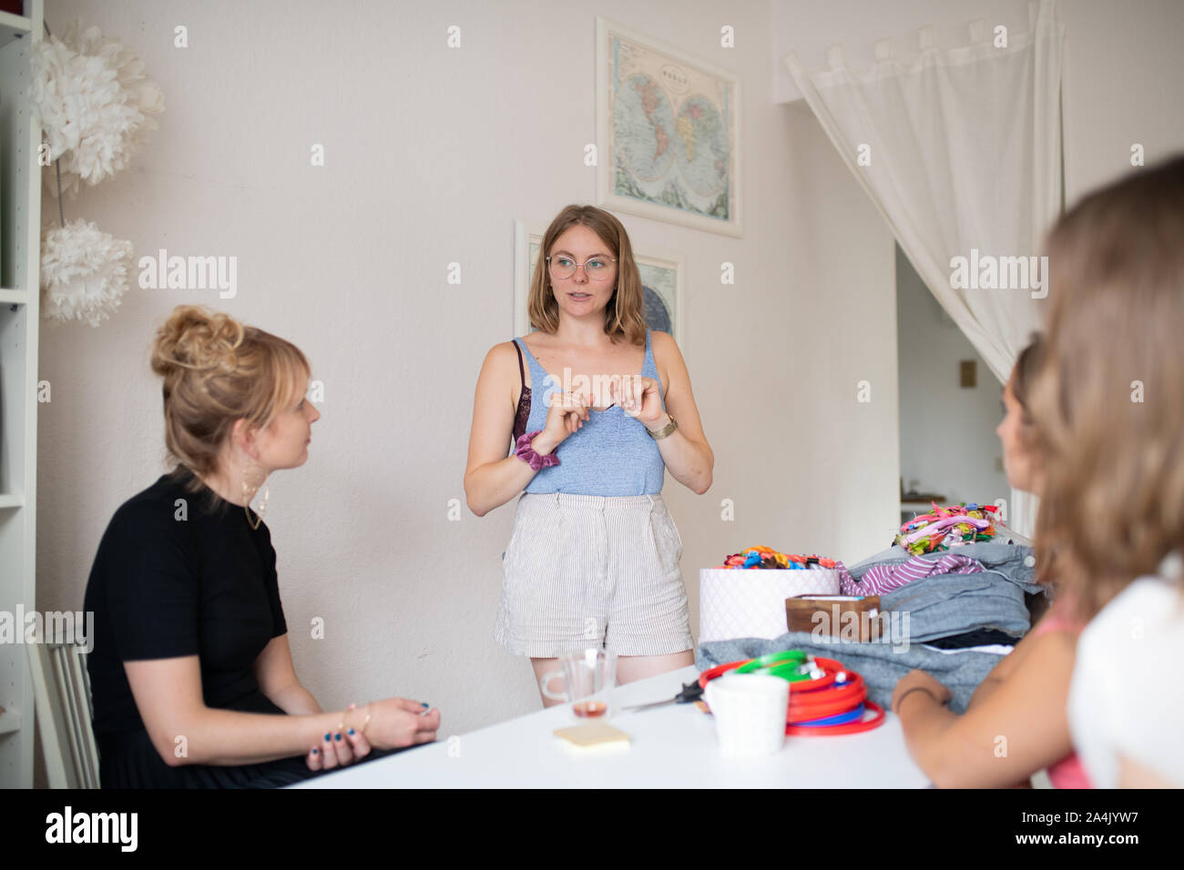 teacher instructing students at embroidery and recycled material class ...