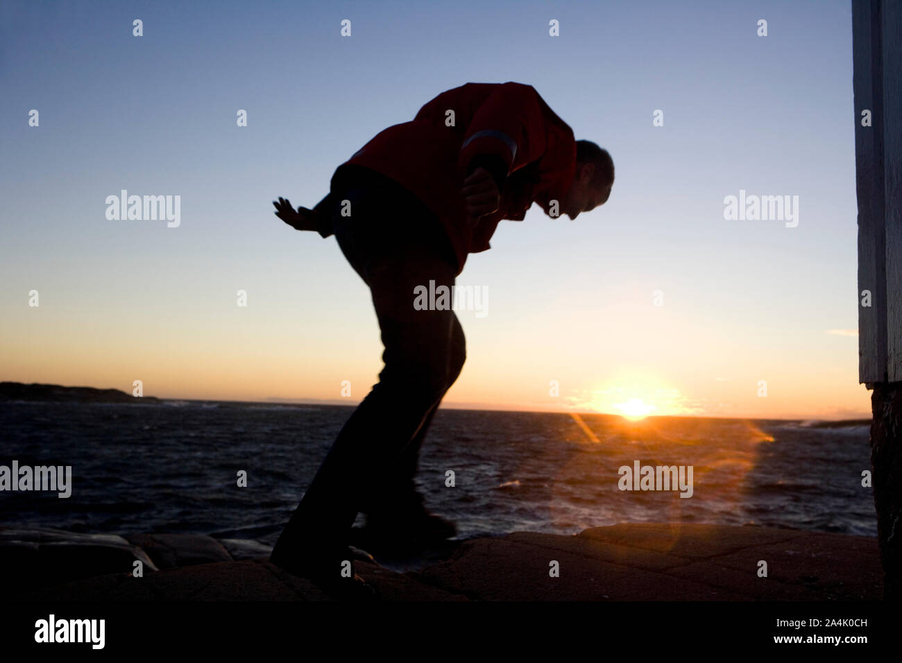 Man leaning into the wind Stock Photo - Alamy