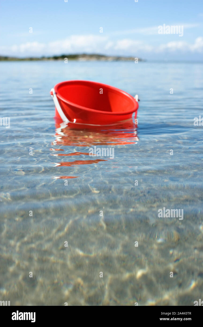 Red bucket floating Stock Photo - Alamy